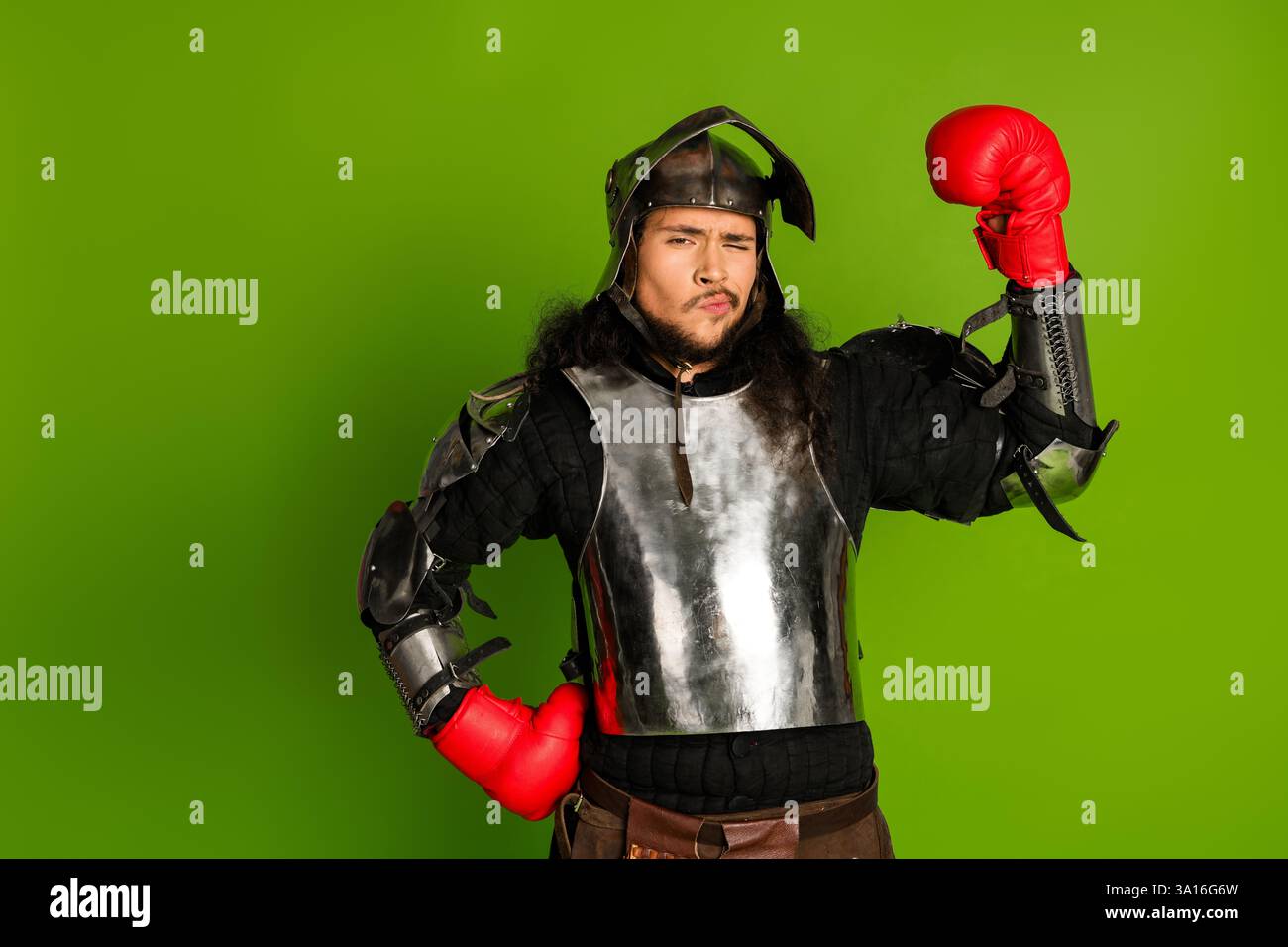 Young man in medieval knight armor with red boxing gloves stands ...