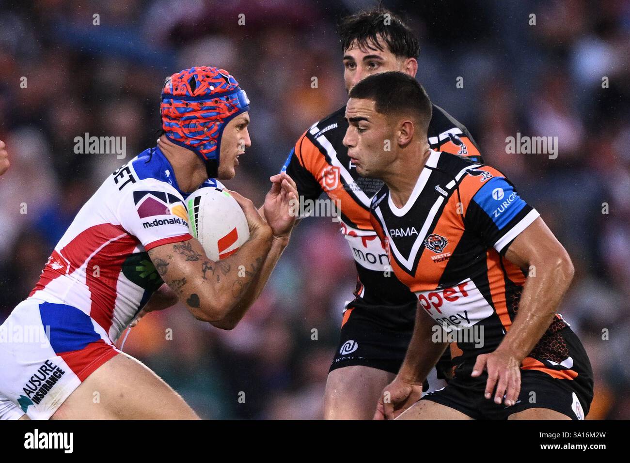 Kalyn Ponga of the Knights is tackled by Tallyn Da Silva of the Tigers ...