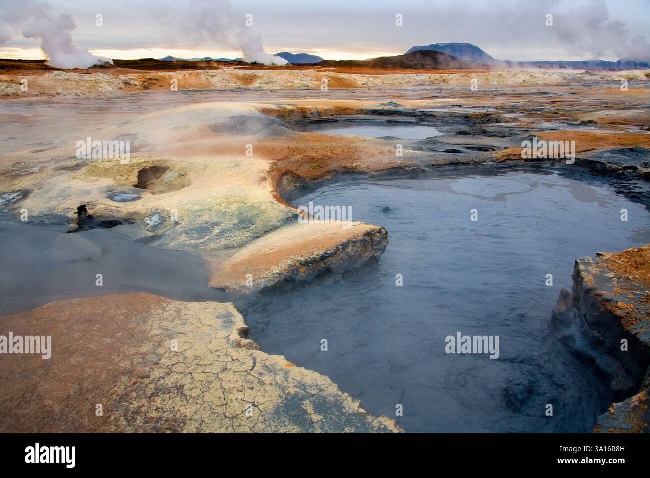 Steaming volcanic fumarole, boiling mud pits and mineral stained earth ...