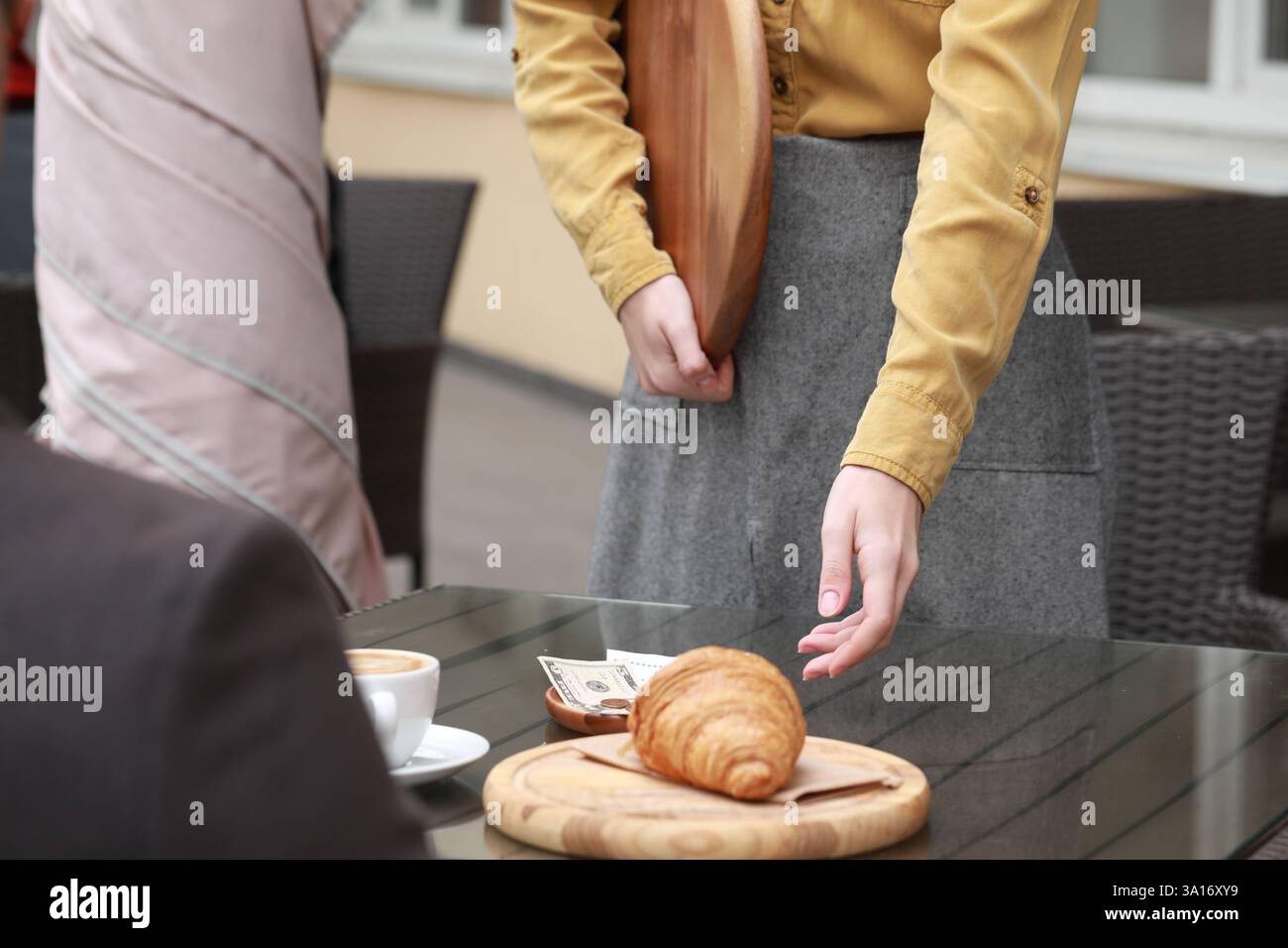 Waitress taking tips from wooden table in outdoor cafe, closeup Stock ...