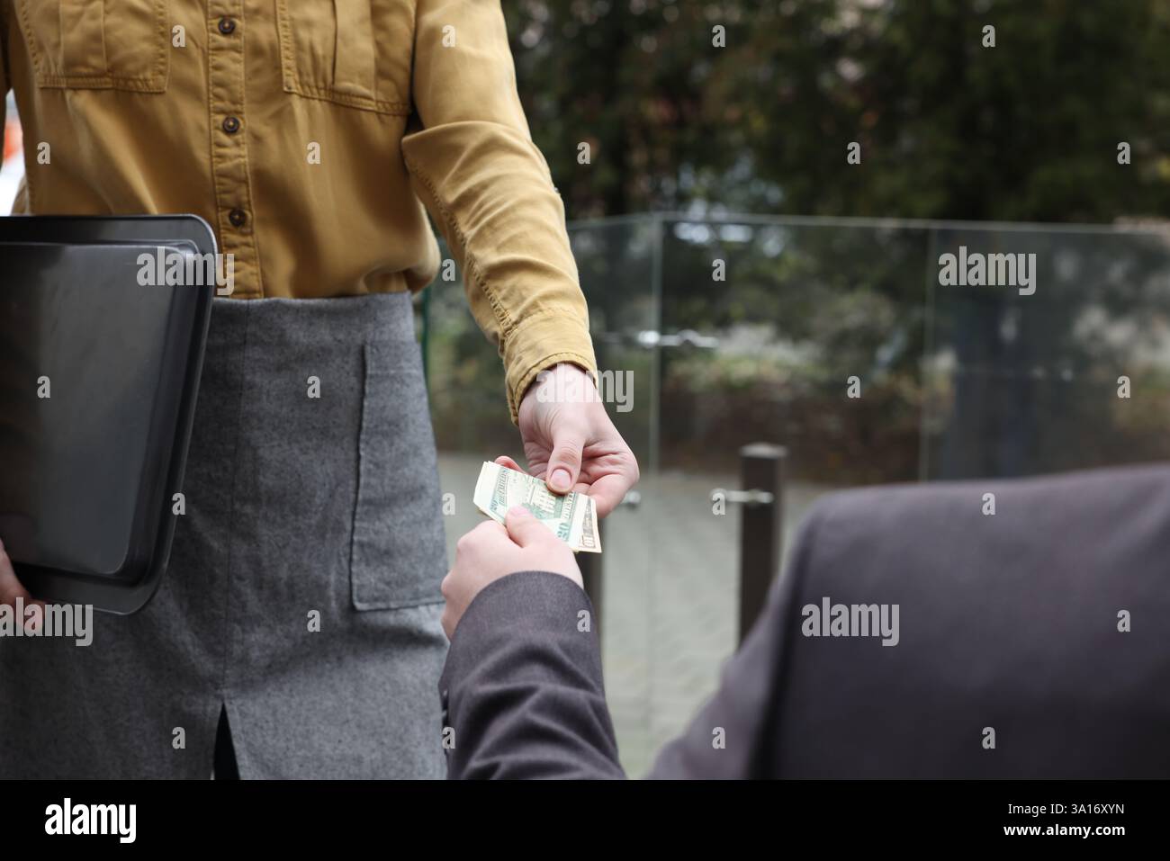 Client giving tips to waitress in outdoor cafe, closeup Stock Photo - Alamy