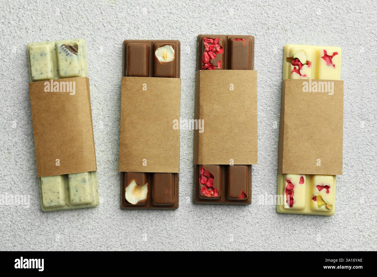 Delicious chocolate bars with different flavors on light table, flat ...