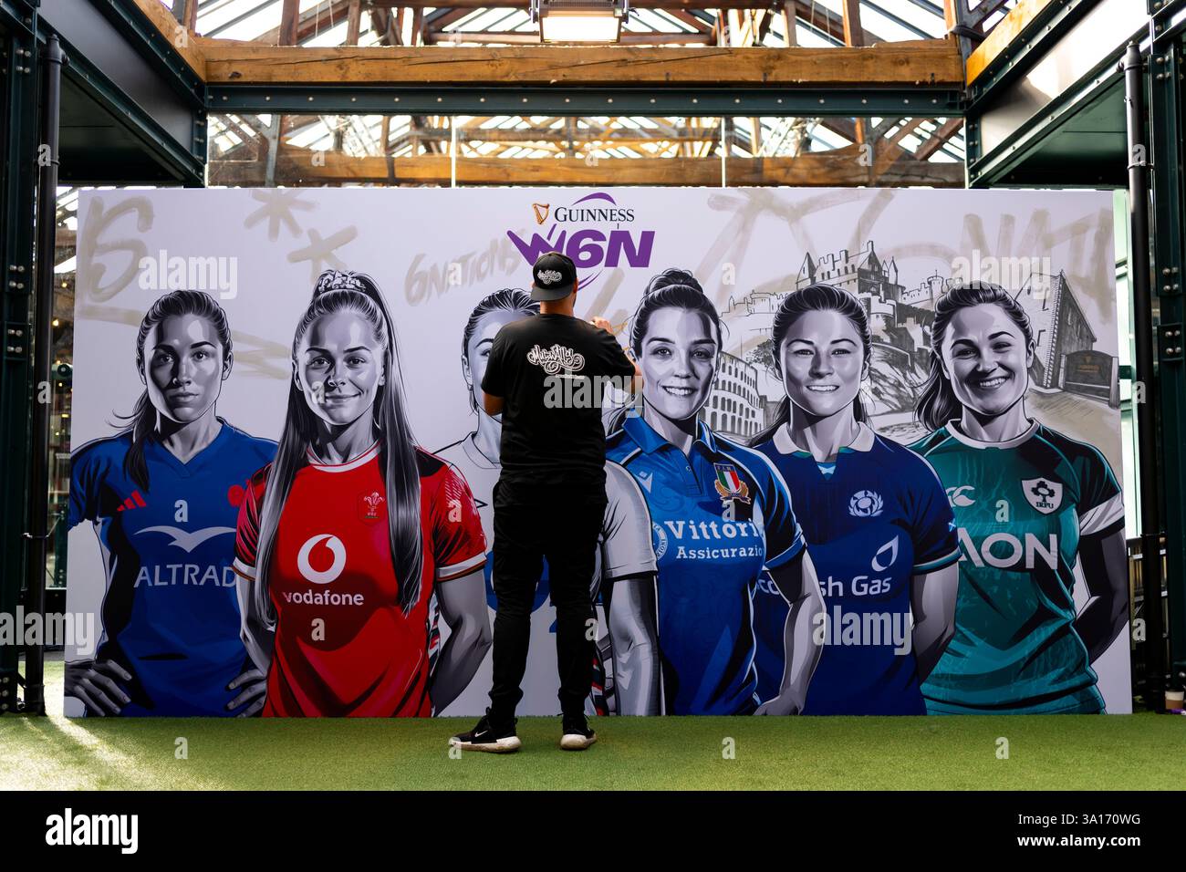 An artist adds the finishing touches to a mural before the launch event ...