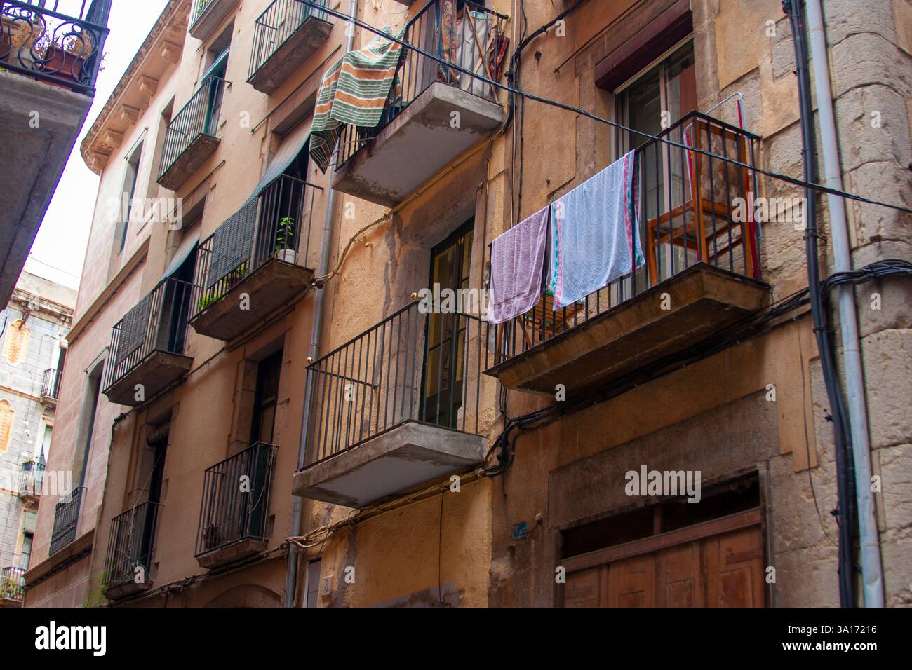 Aged building facade with balconies and wrought-iron railings. Girona ...