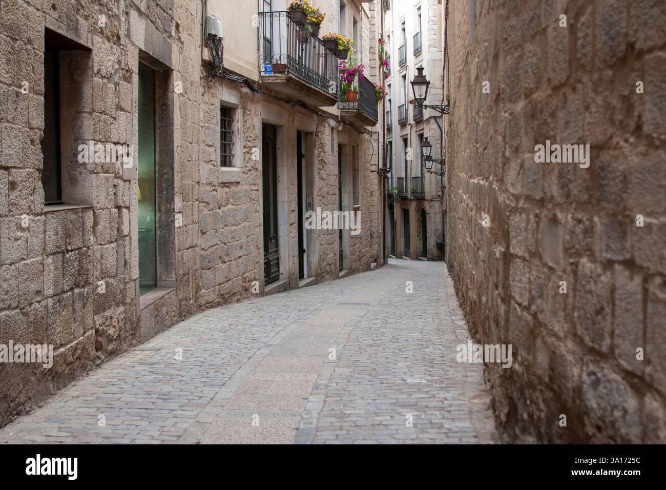 Cobblestone street winding between historic buildings. Aged stone walls ...