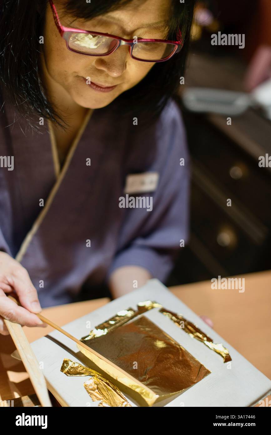 Kuniko Kawamura uses a bamboo chopstick-like implement to move a 0.0001 mm thick sheet of gold ...