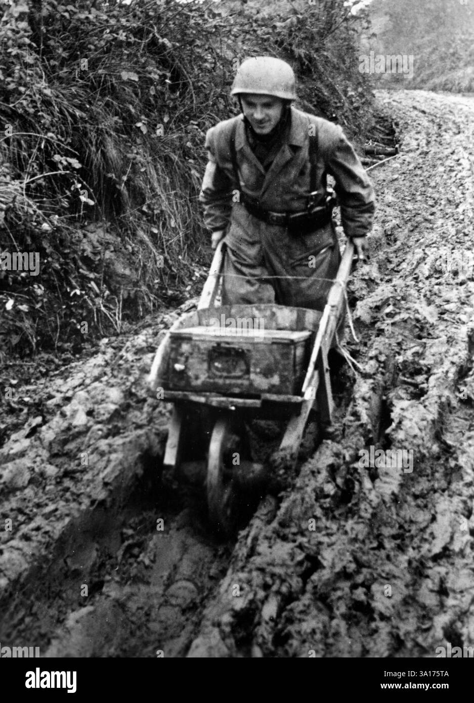 A paratrooper carries an ammunition crate into the position in a ...