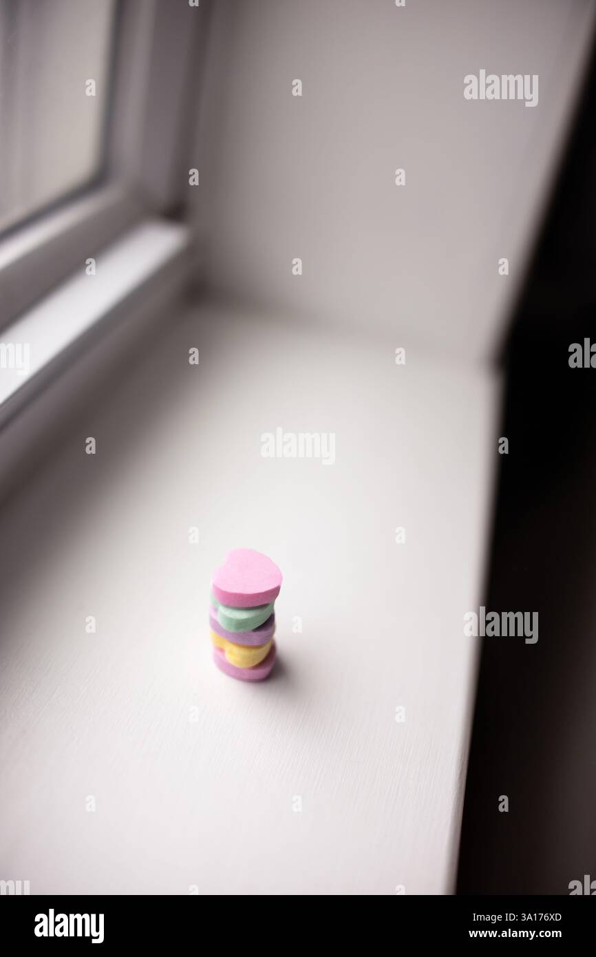 stacked pastel candy hearts on white window sill Stock Photo - Alamy