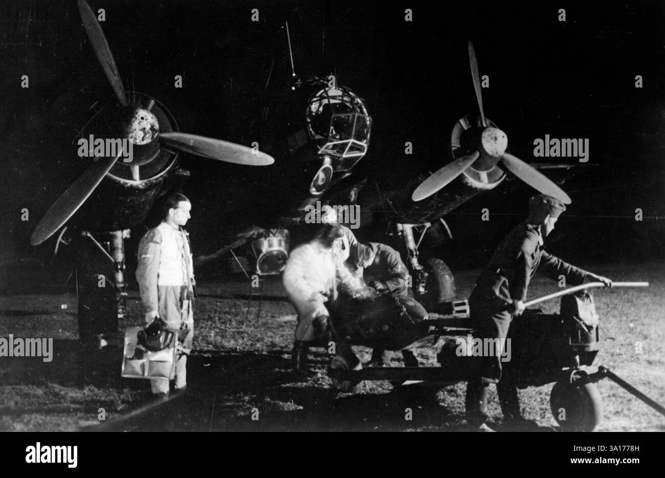 A German Junkers Ju 88 fighter plane is loaded with bombs for a night ...