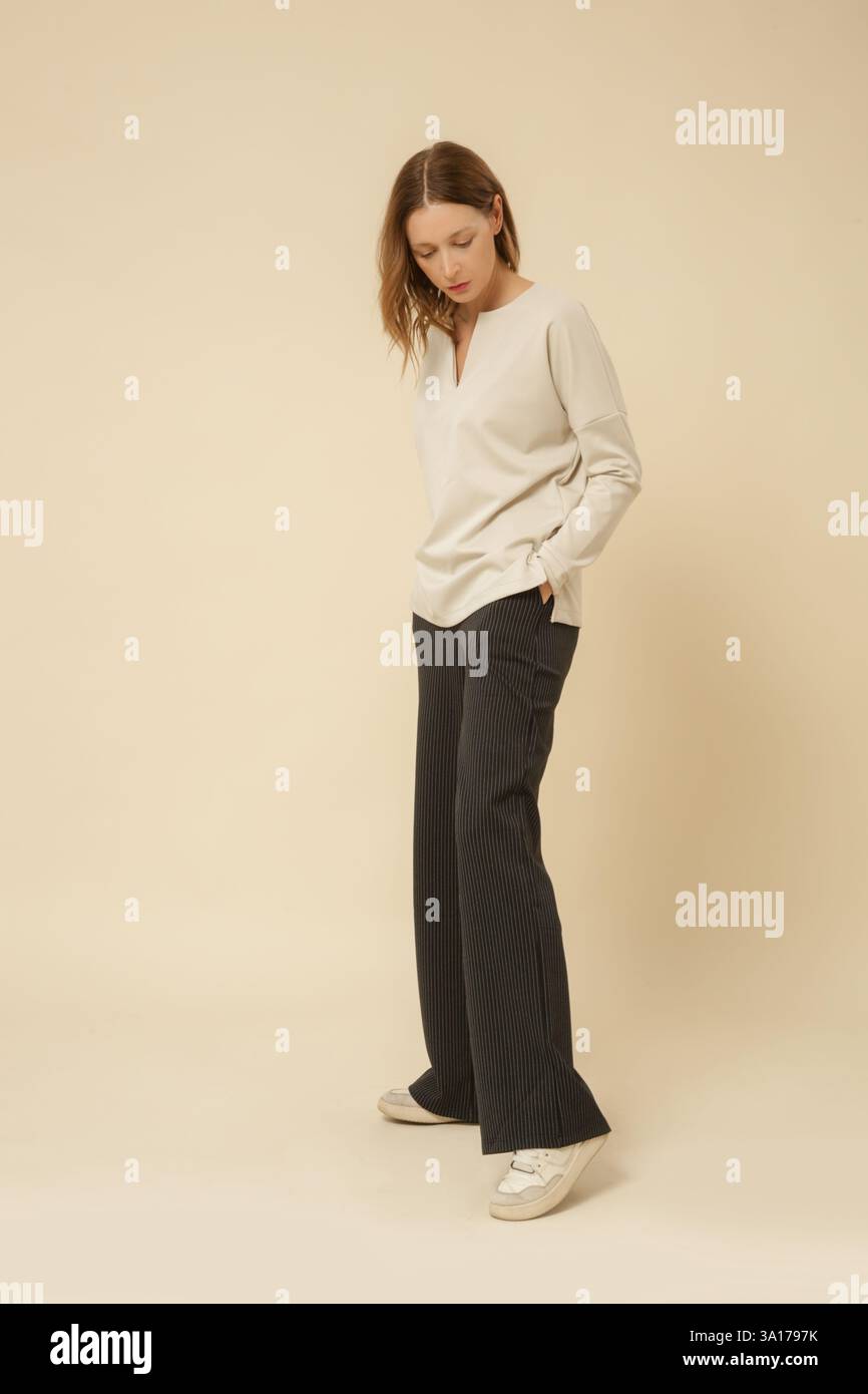 Female model wearing striped black and white trousers and white shirt ...