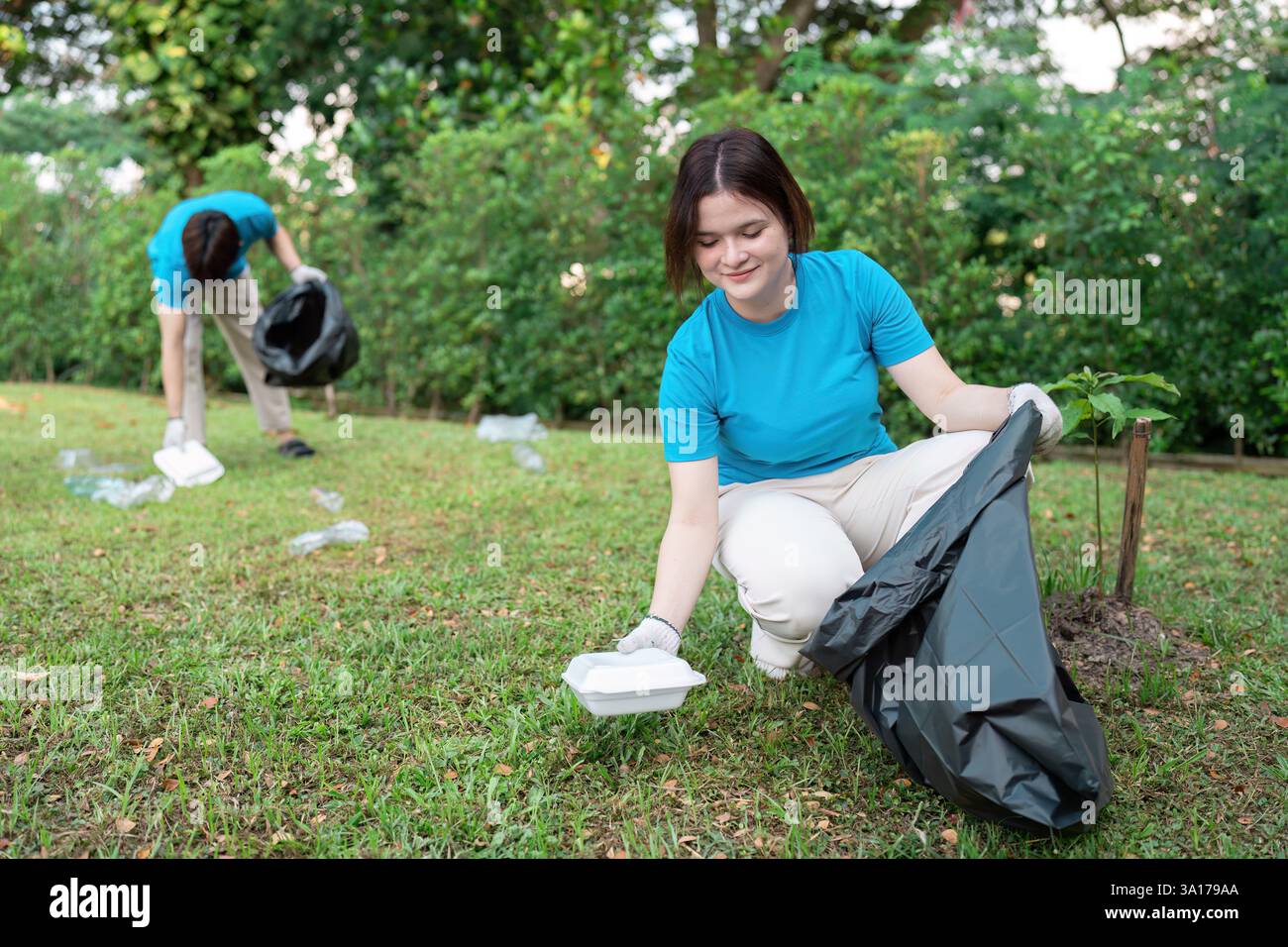 Eco-friendly cleanup initiative. Volunteers collecting litter in a park ...