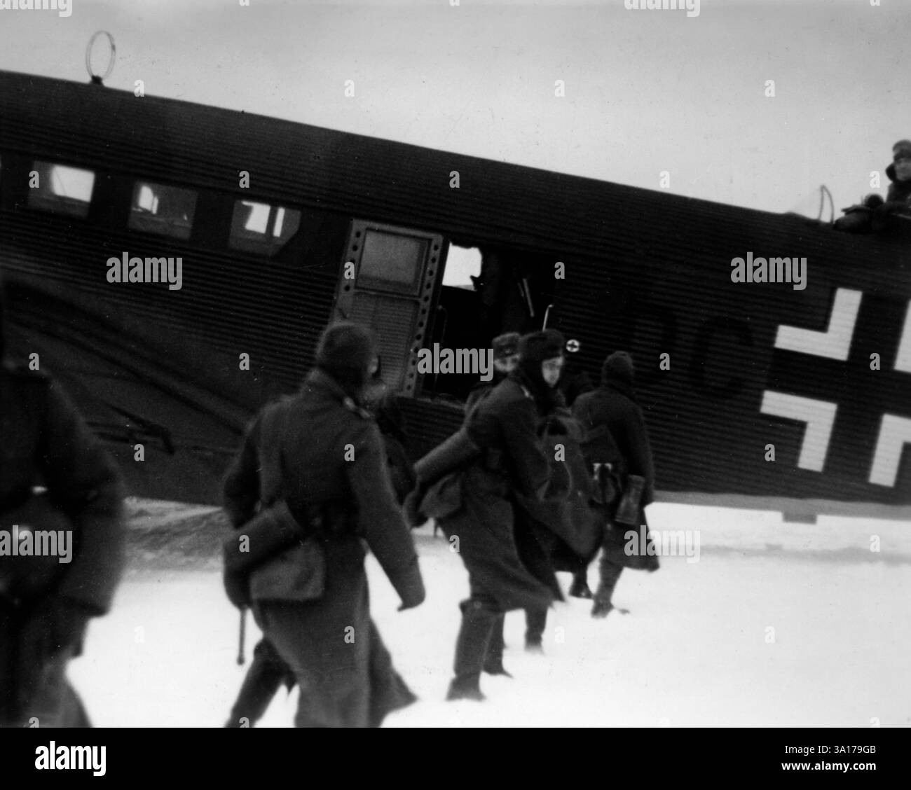 Soldiers board a Junkers Ju 52 transport plane at a field airfield near ...