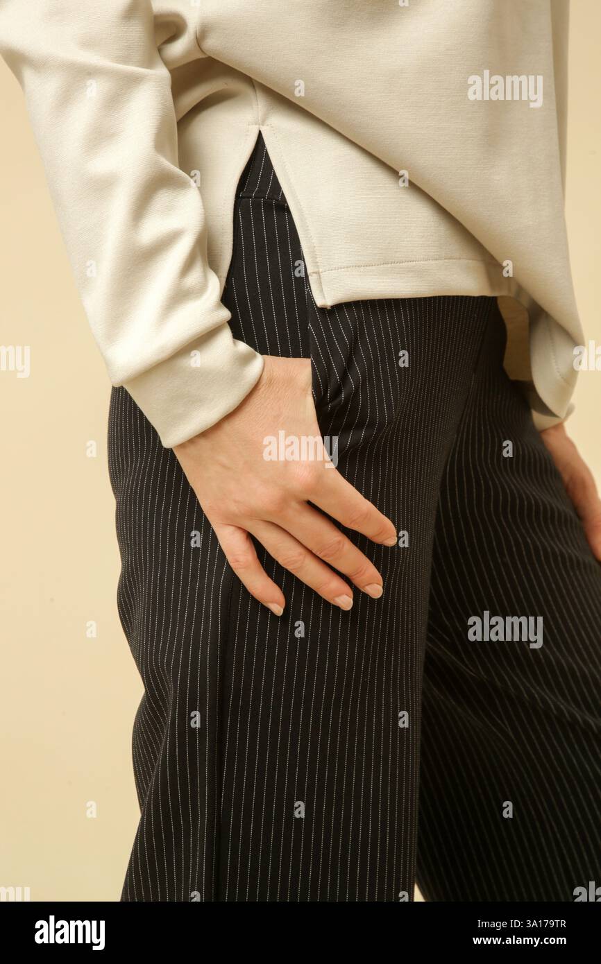 Female model wearing striped black and white trousers and white shirt ...