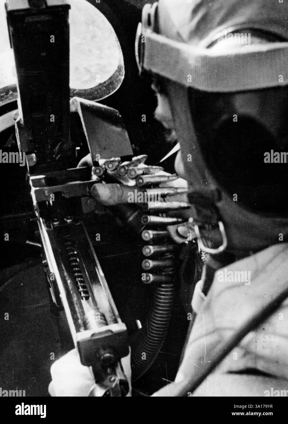 Gunner of a long-range reconnaissance aircraft loads the machine gun ...