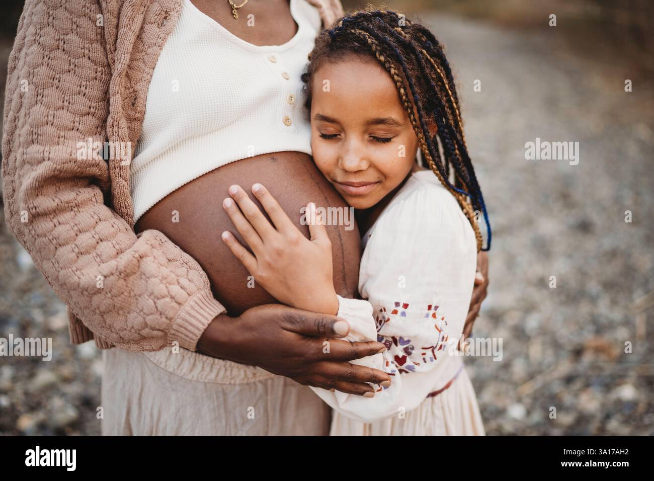 Smiling black mix race girl hugging black pregnant mom belly Stock ...