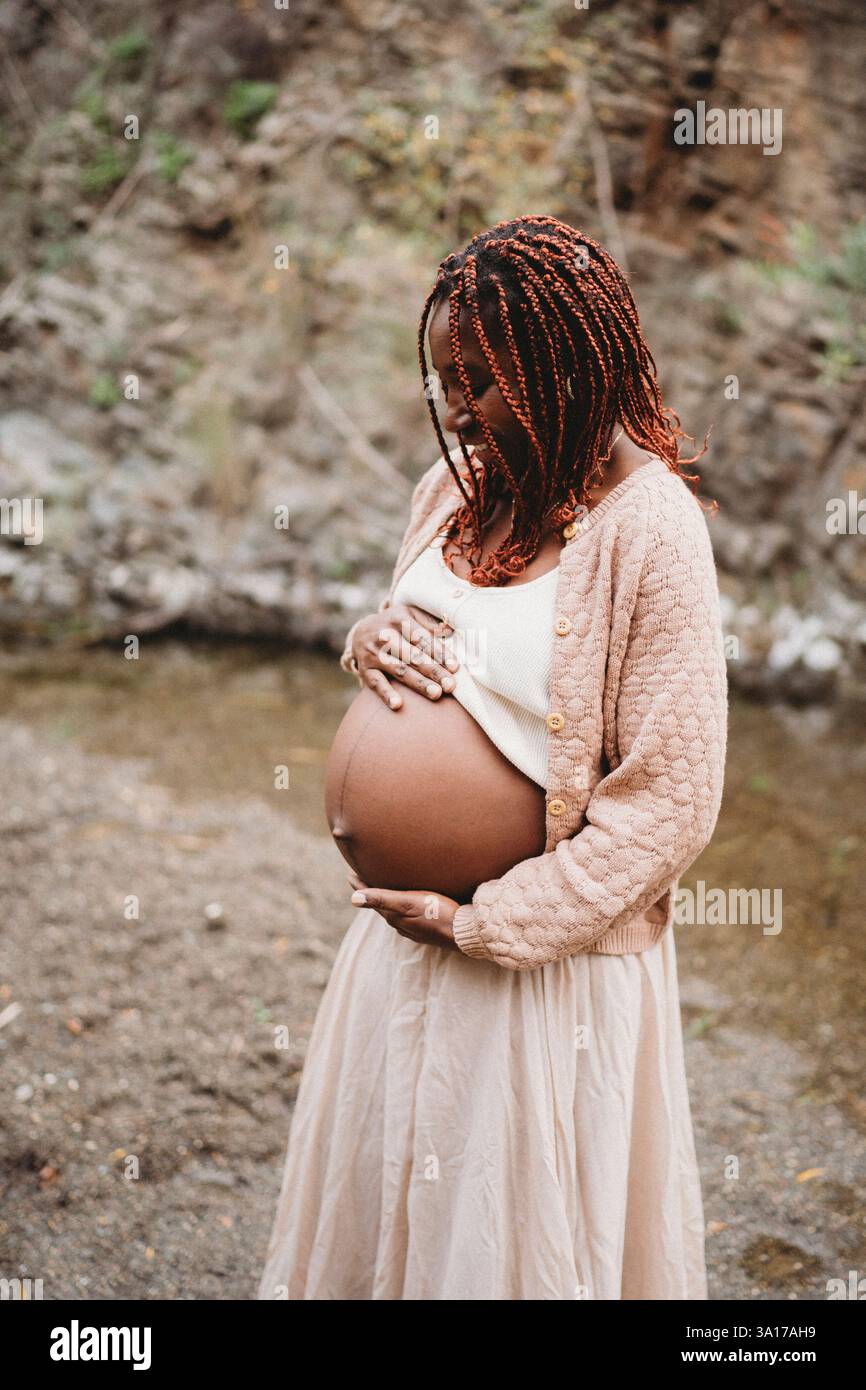 Black expecting pregnant woman outside by stream Stock Photo - Alamy