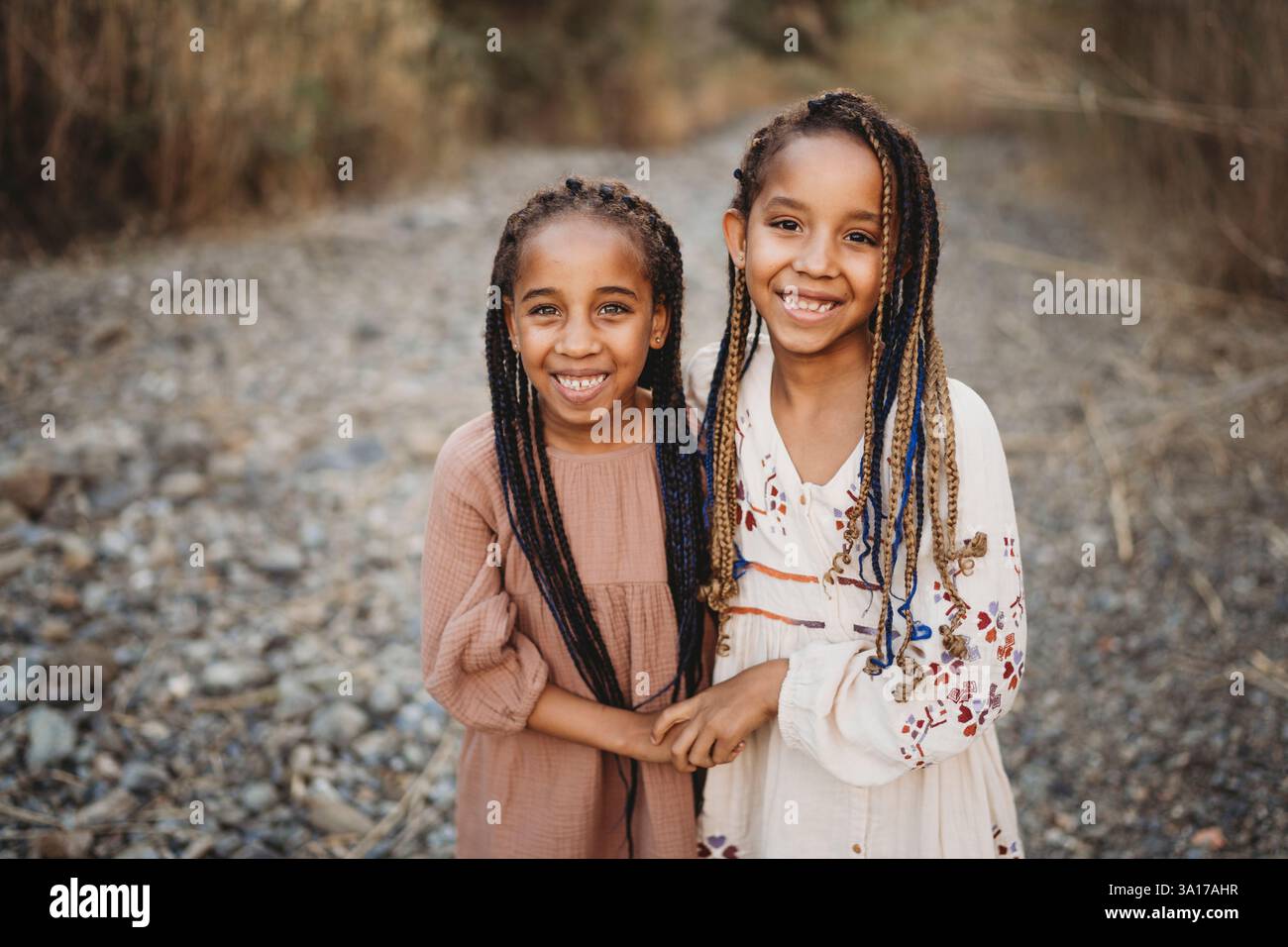 Black mixed race girls sisters smiling in fields with rocks Stock Photo ...