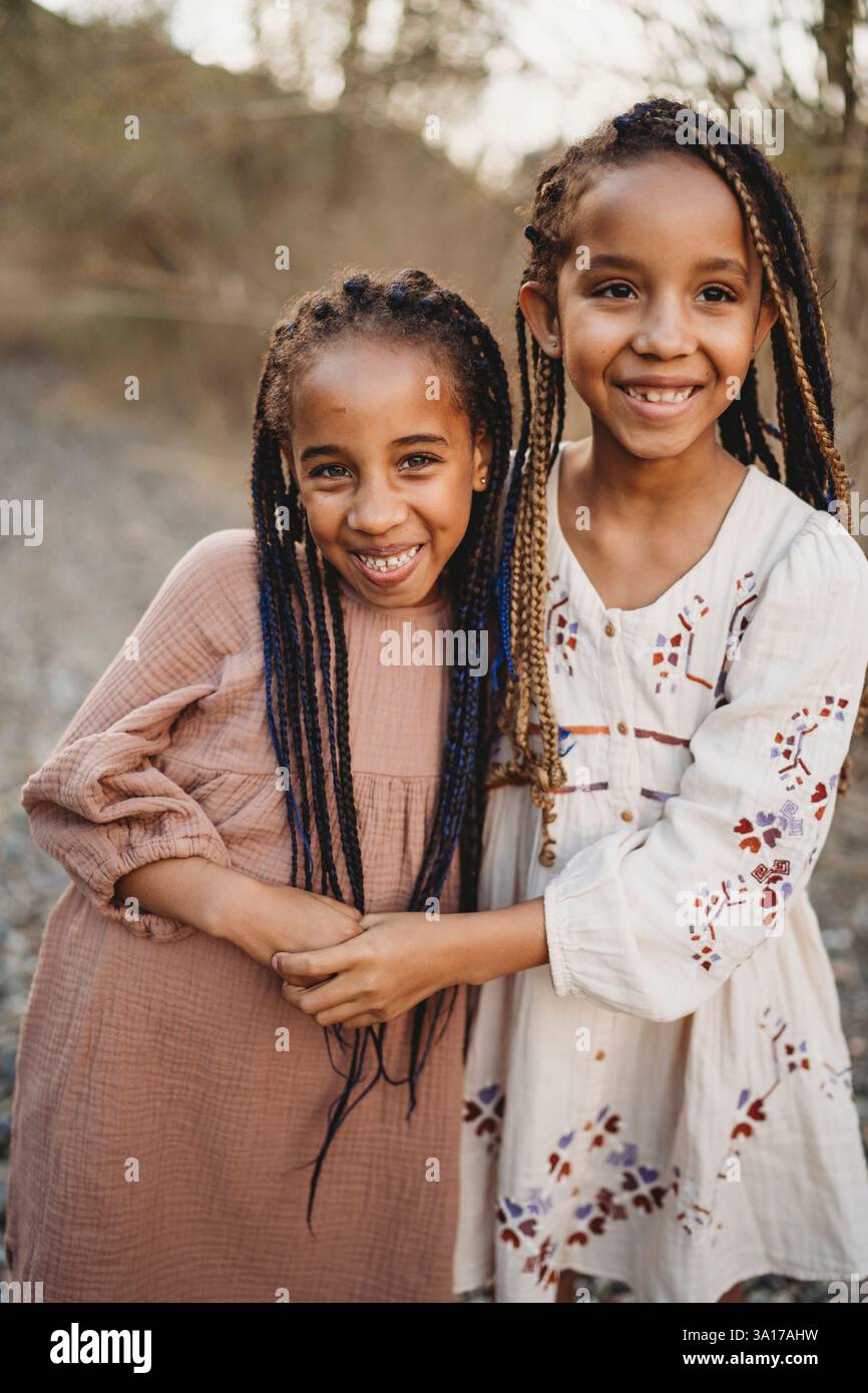 Black mixed race girls sisters smiling in fields with rocks Stock Photo ...