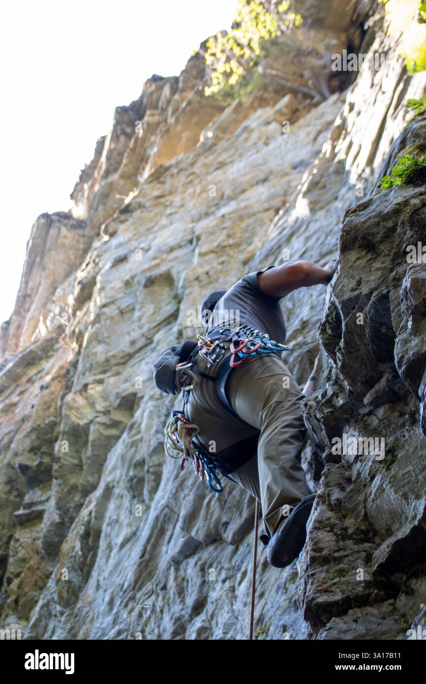 A rock climber ascends a steep cliff using ropes and climbing gear Stock Photo - Alamy