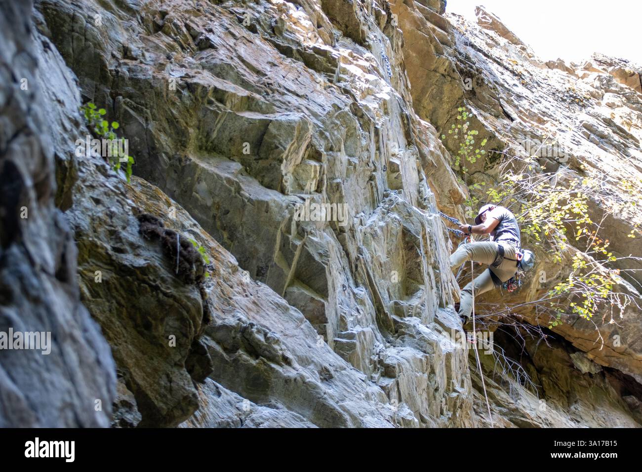 A rock climber ascends a steep cliff using ropes and climbing gear Stock Photo - Alamy