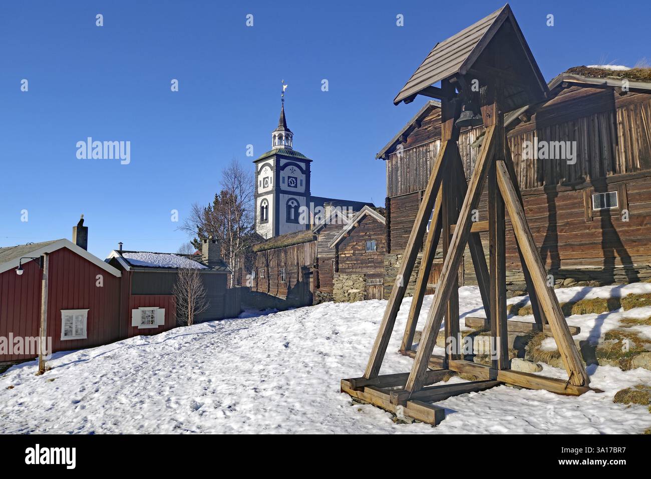 Idyllic village view with snow-covered wooden houses and a church tower ...