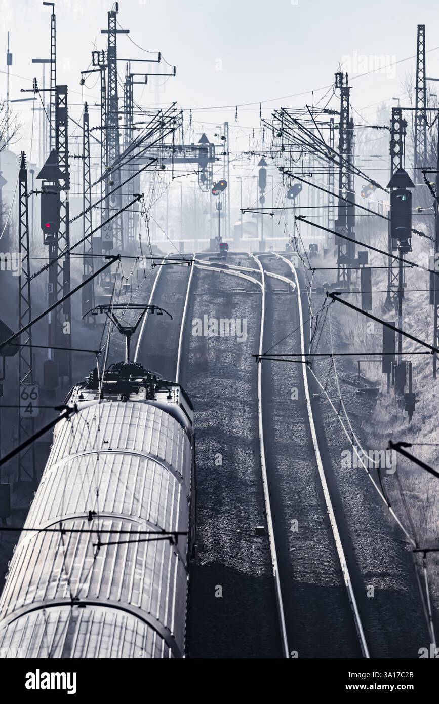Deutsche Bahn AG tracks against the light. Overhead line, signals and ...