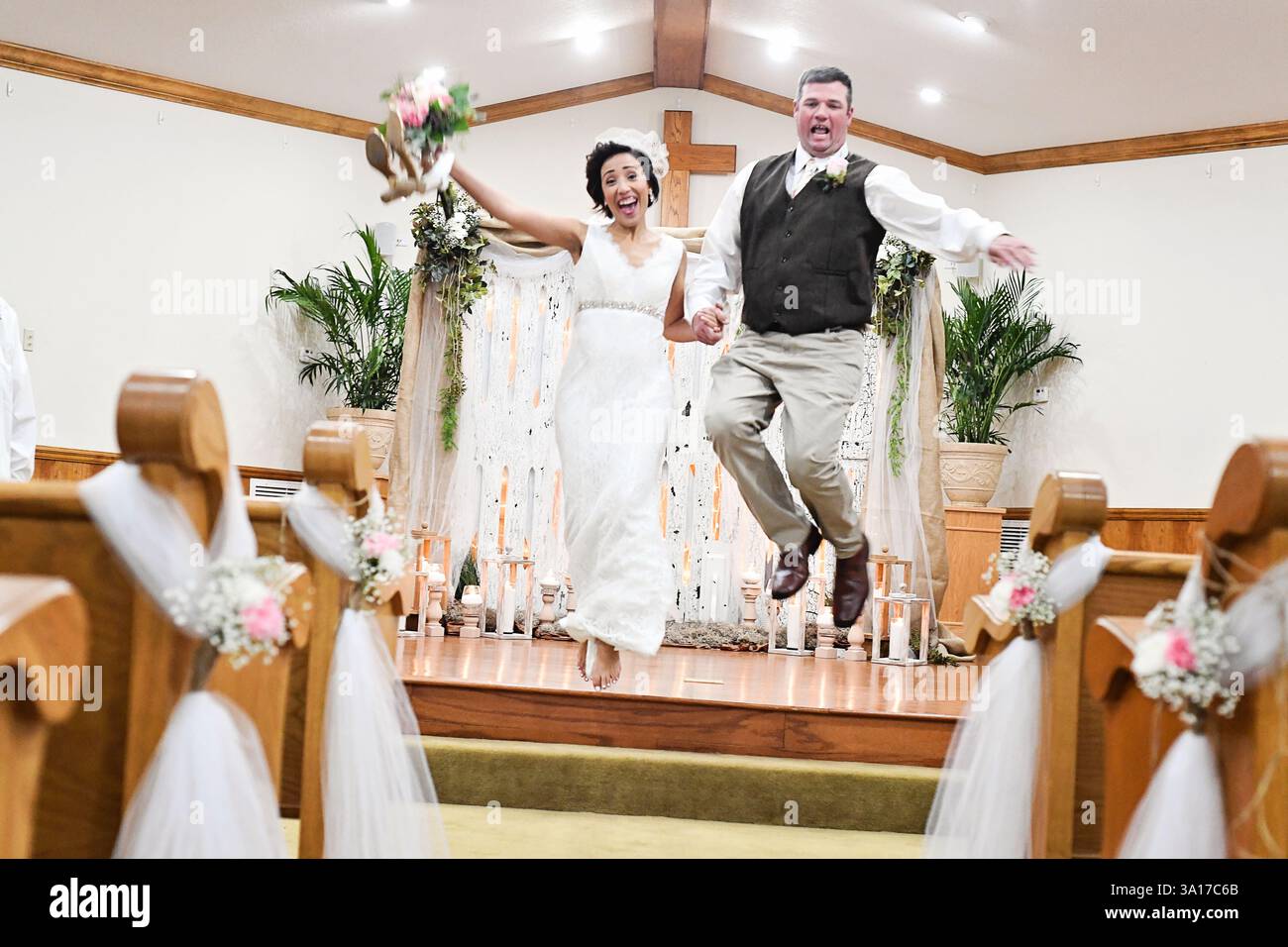 Newlyweds joyfully jump together in a rustic wedding ceremony Stock ...