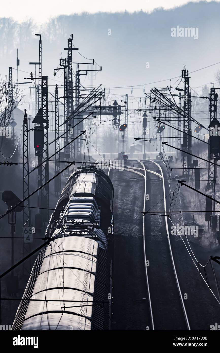 Deutsche Bahn AG tracks backlit with goods train. Overhead line ...