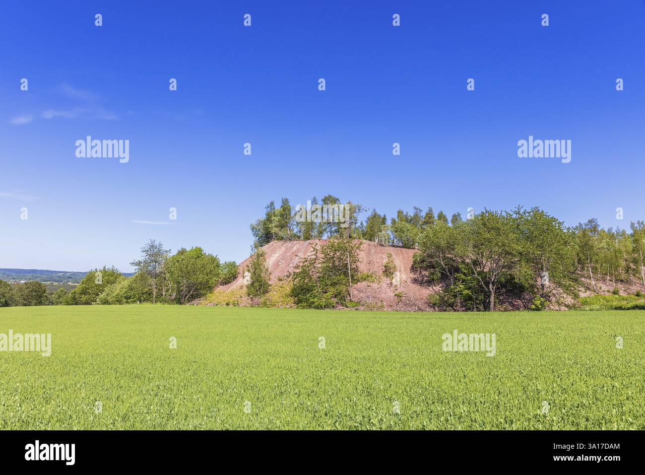 Pile of slag dumps from a Limestone quarry by a lush green field in the ...