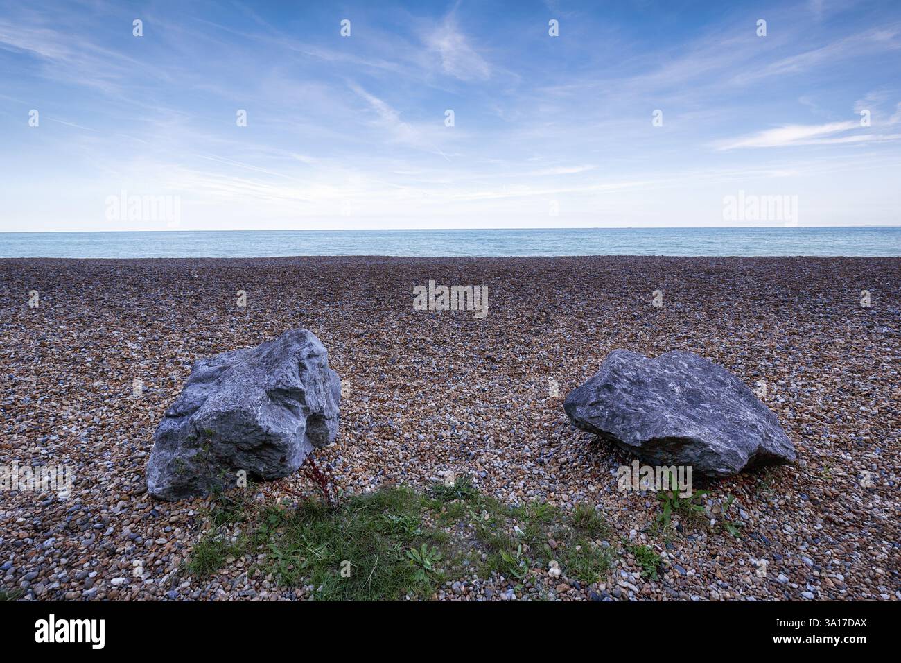 Two boulders on an empty shingle beach, Kingsdown Beach in the evening ...