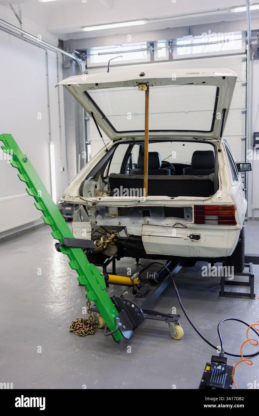 In a modern workshop, a classic car is being meticulously restored. The ...