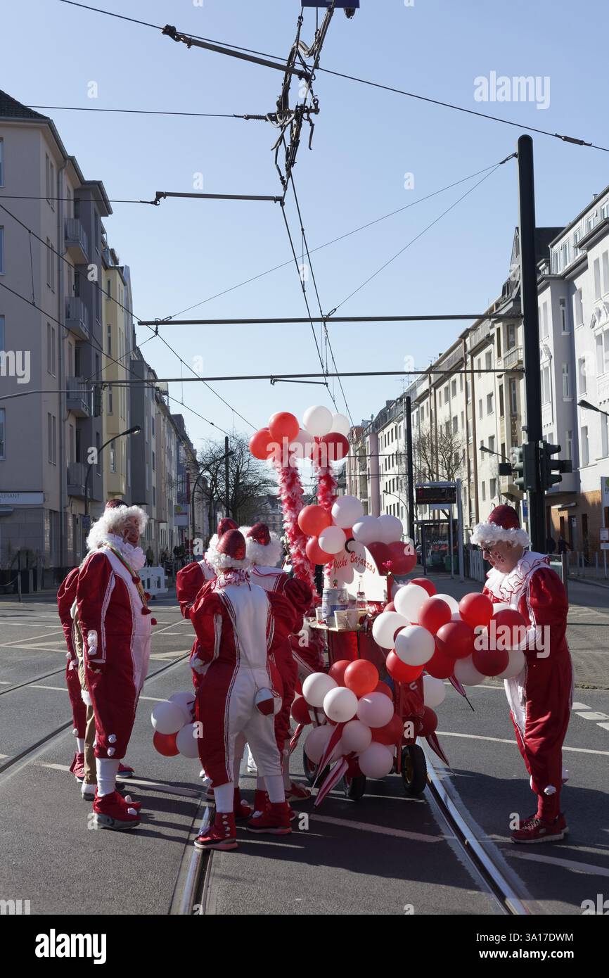 Group in red and white clown costumes on an empty street, Jecke ...