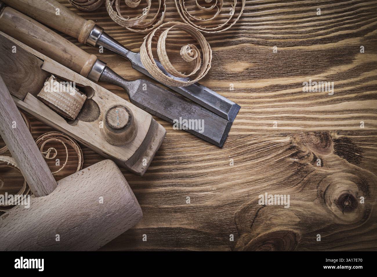 Flat chisels shaving plane curled shavings lump hammer on wooden board ...