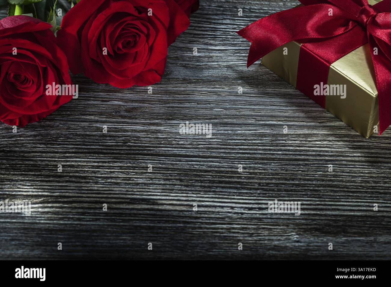 Golden gift box red roses on wooden board Stock Photo - Alamy