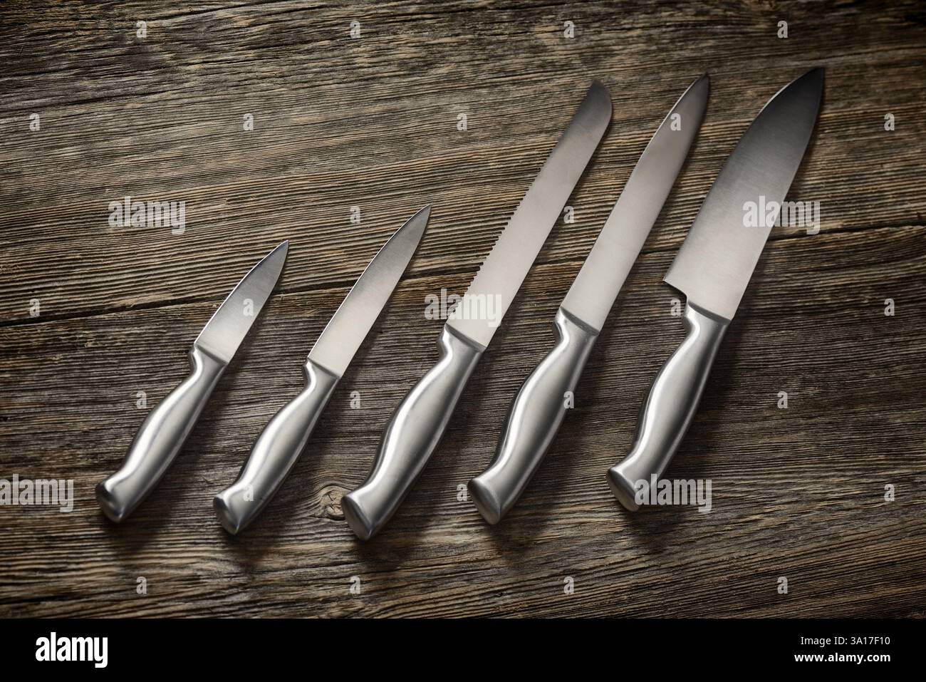 Metal kitchen knives set on rustic wood background Stock Photo - Alamy