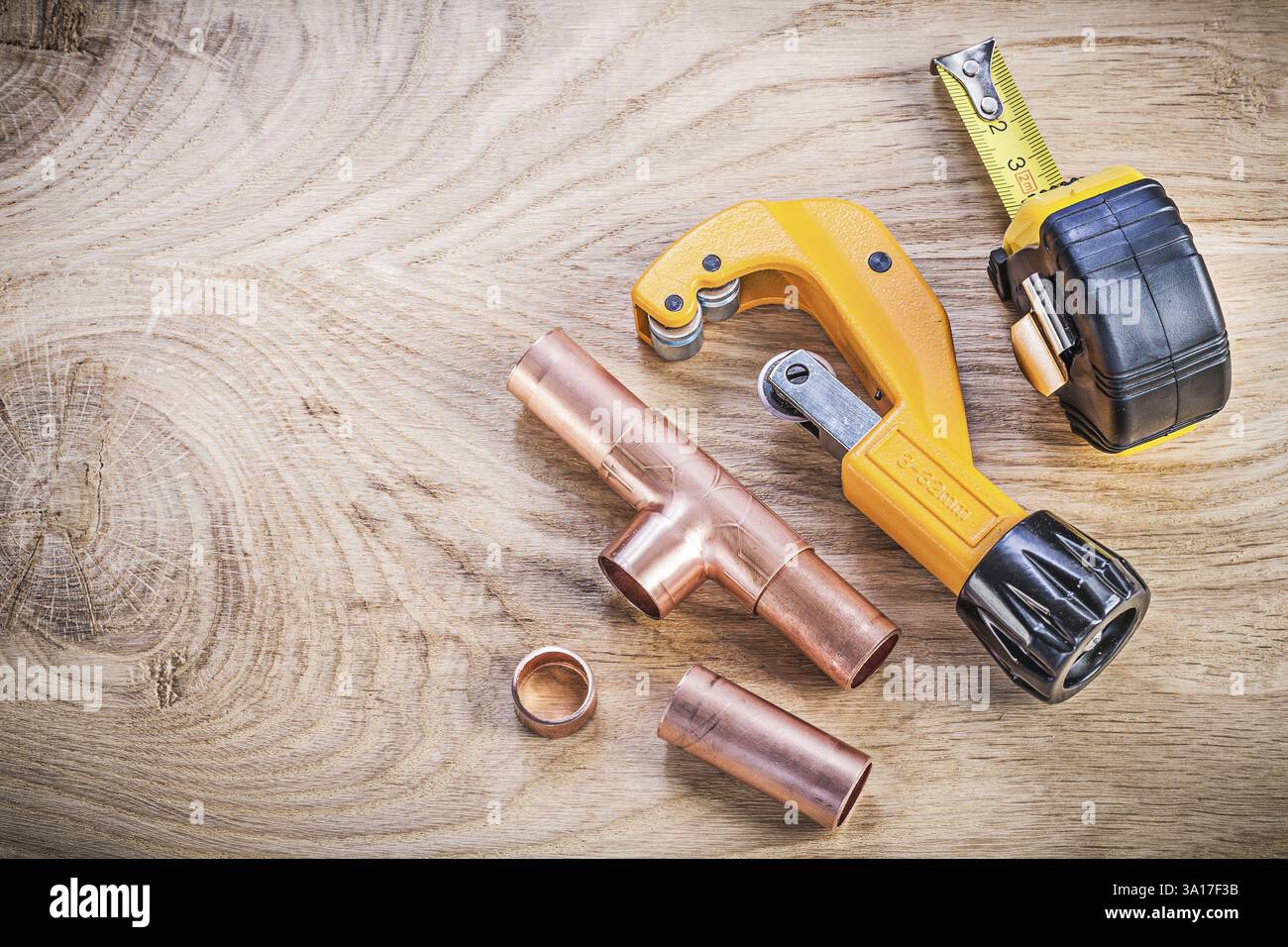 Copper water pipe cutter fittings tape measure on wood board top view ...