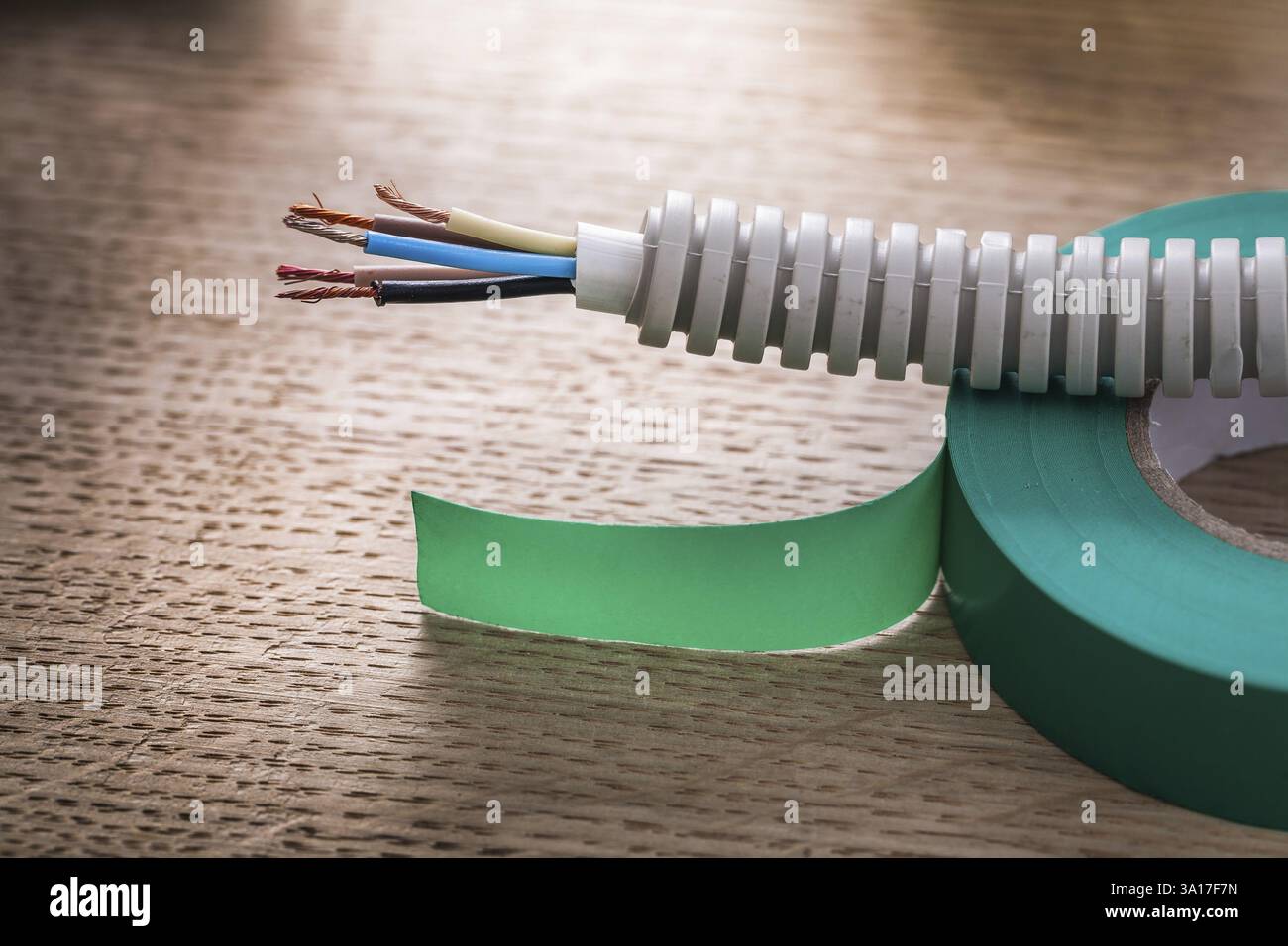 Electric cable in corrugated pipe on roll of green insulating tape ...