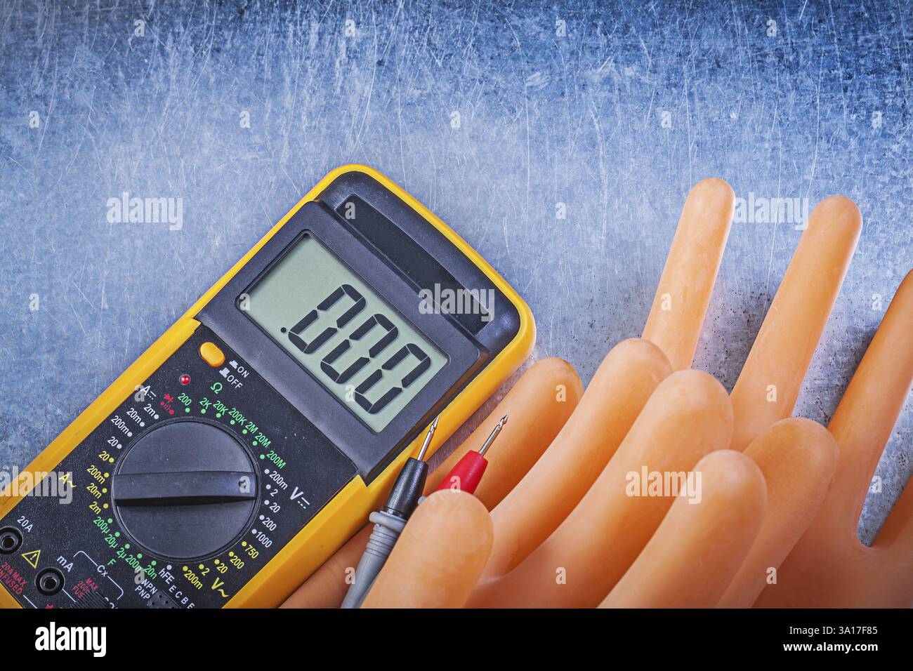Digital multimeter insulating rubber gloves on metallic background ...