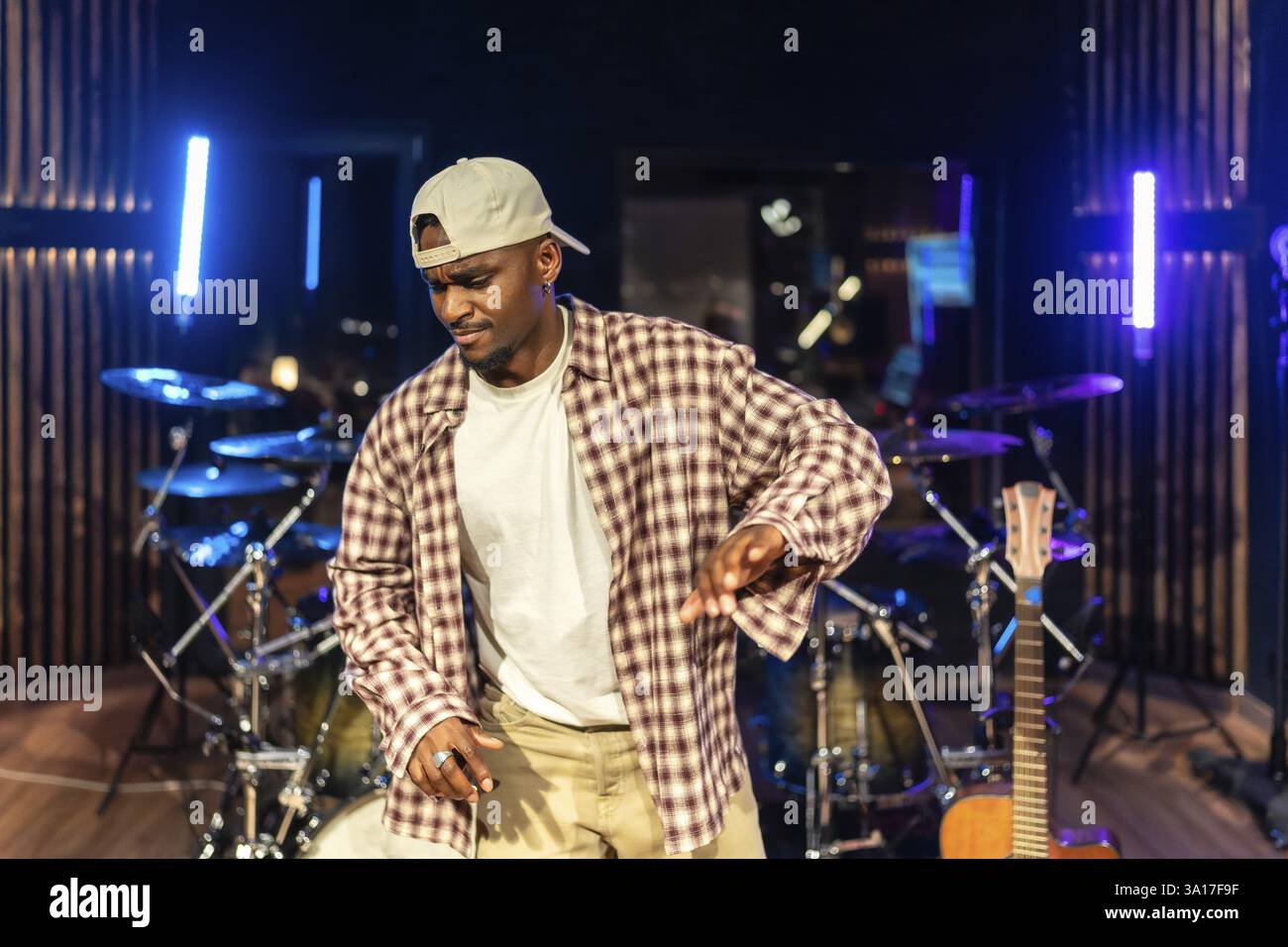 Young male musician dancing and performing urban dance in music studio ...