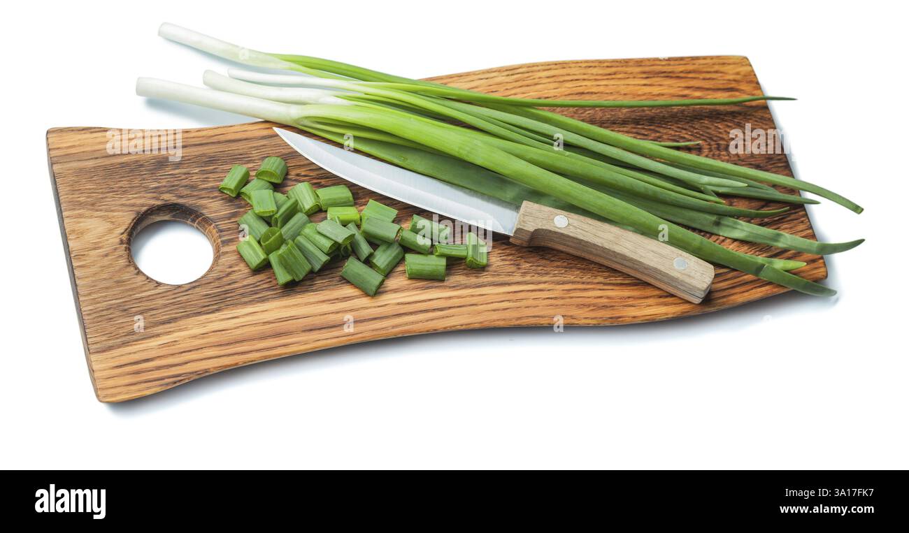 Green chopped scallions and kitchen knife on vintage wooden chopping ...