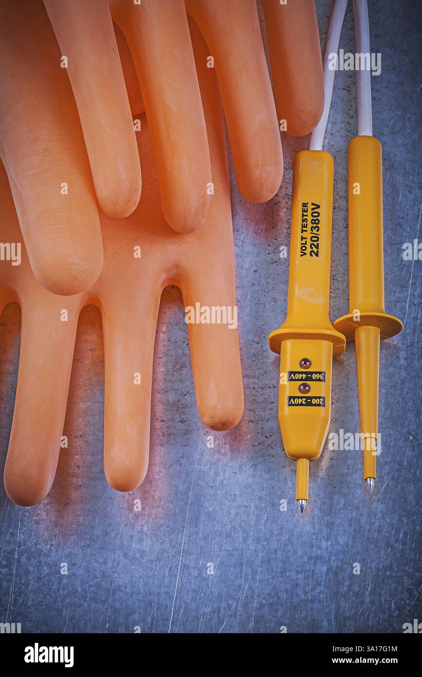 Electricians gloves electric tester on metallic background electricity ...