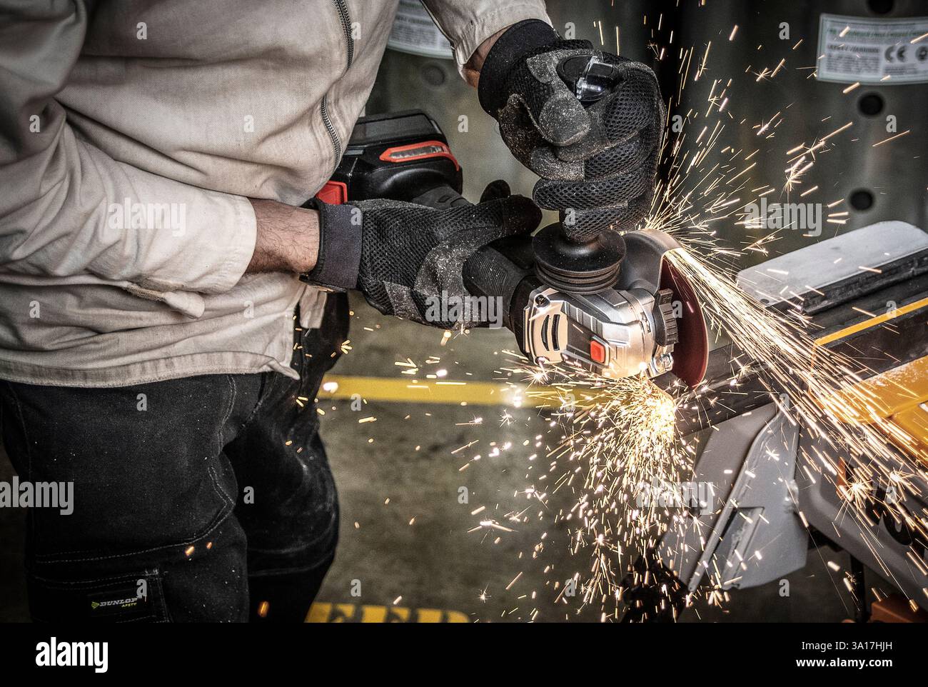 A male metalworker using an angle grinder cutting metal creating a lot of sparks Stock Photo - Alamy