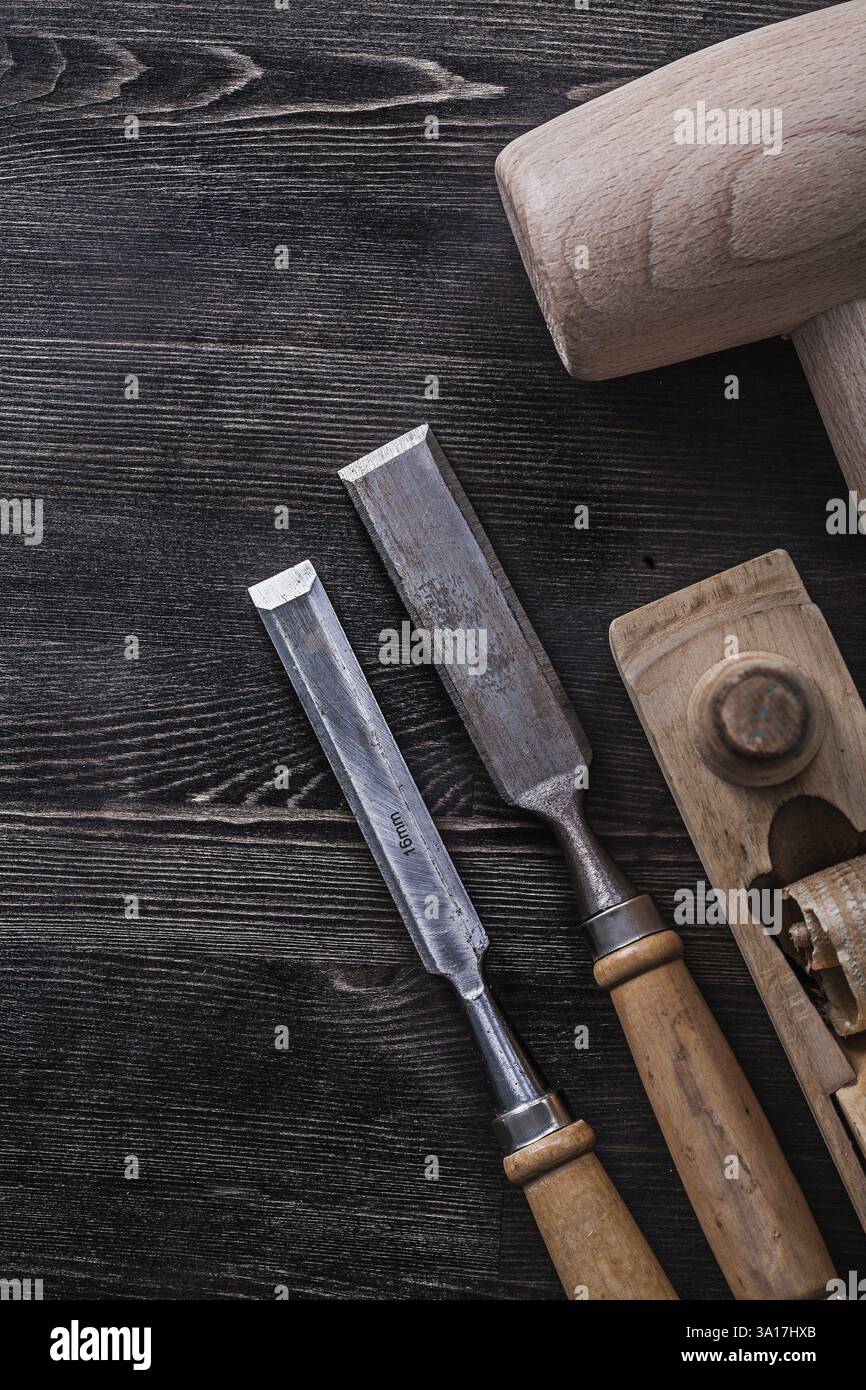 Flat chisels wooden hammer planer on wood board construction concept ...