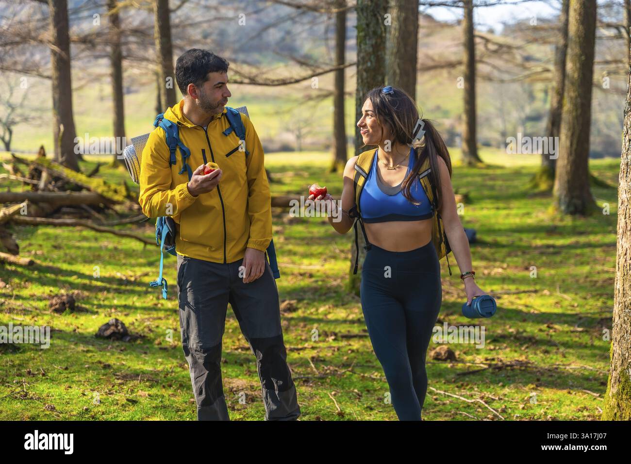 Hikers enjoying a healthy snack of apples while walking through a sunny ...