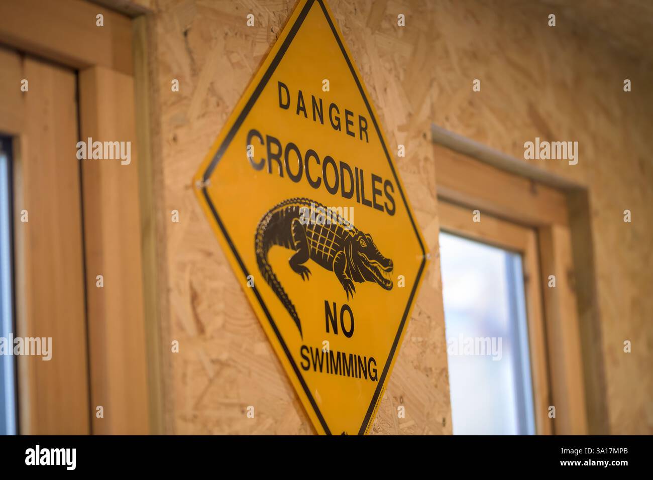 Yellow caution sign with the text 'Danger Crocodiles No Swimming ...