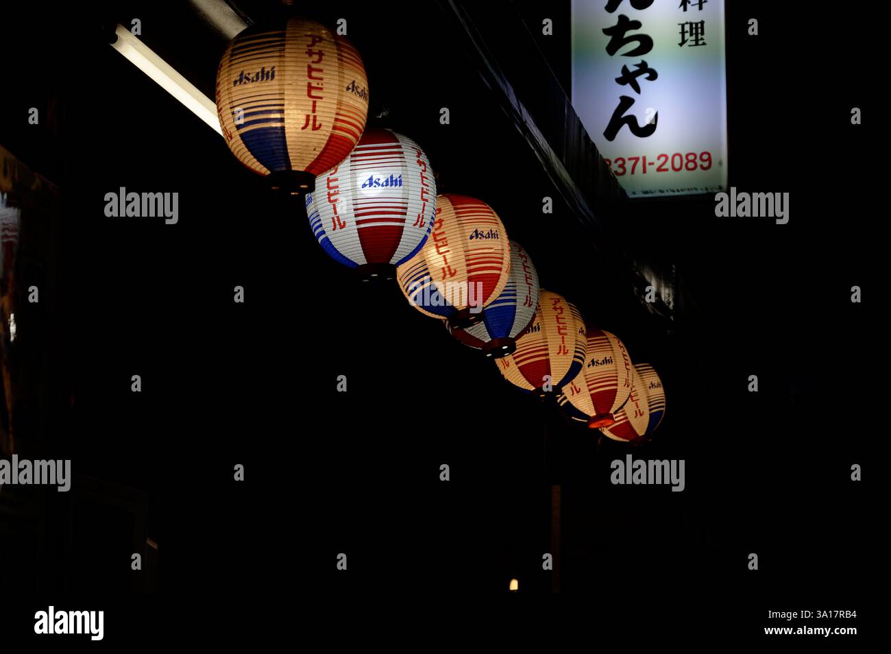Glowing paper lanterns adorned with Japanese characters and the Asahi ...