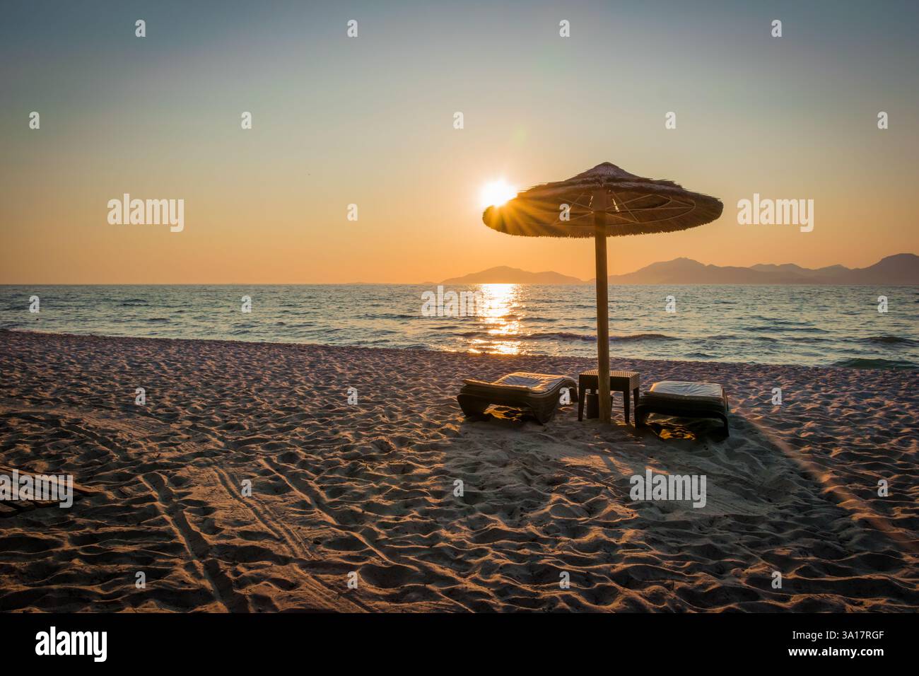 Beach sunset setting behind Kalymnos island from Kos island, Greece ...