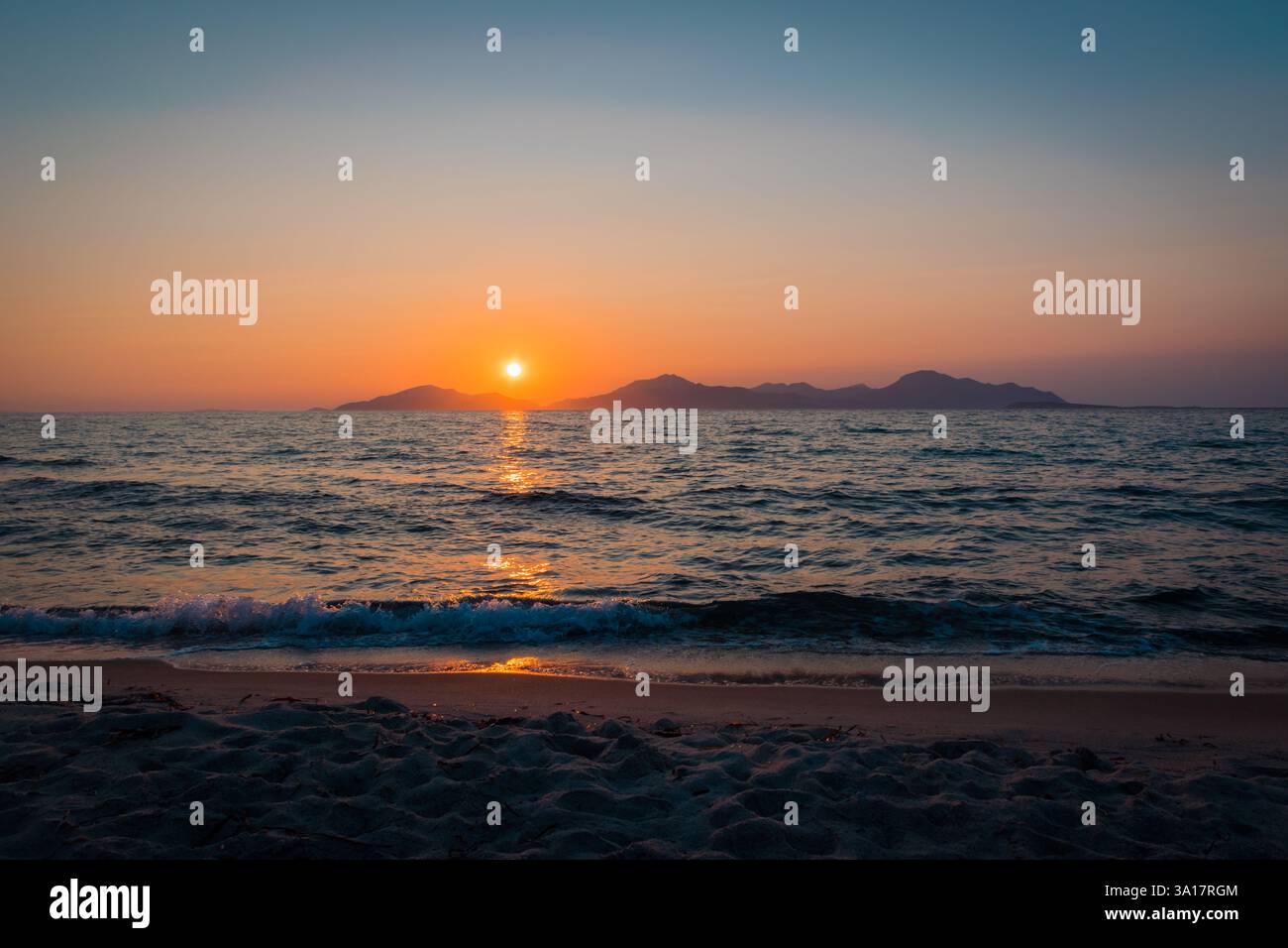 Beach sunset setting behind Kalymnos island from Kos island, Greece ...