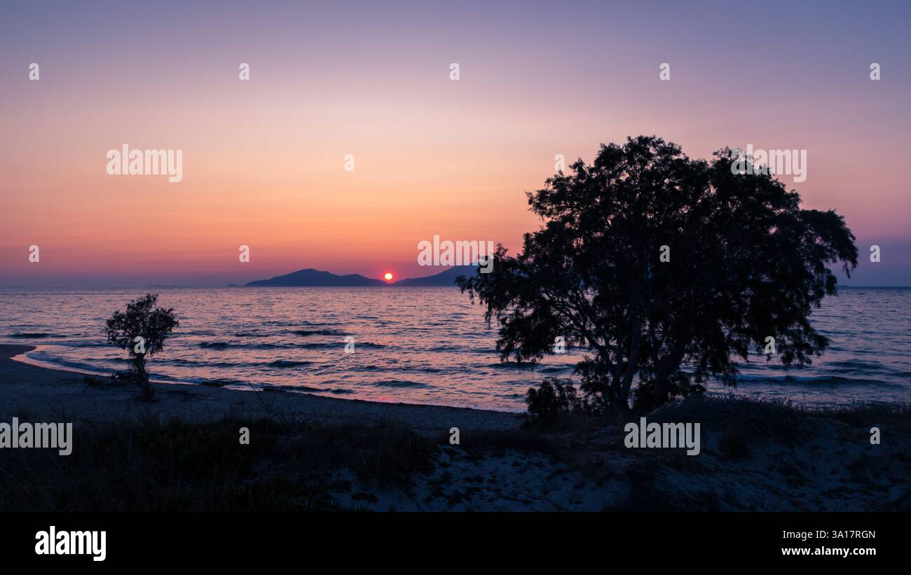 Beach sunset setting behind Kalymnos island from Kos island, Greece ...