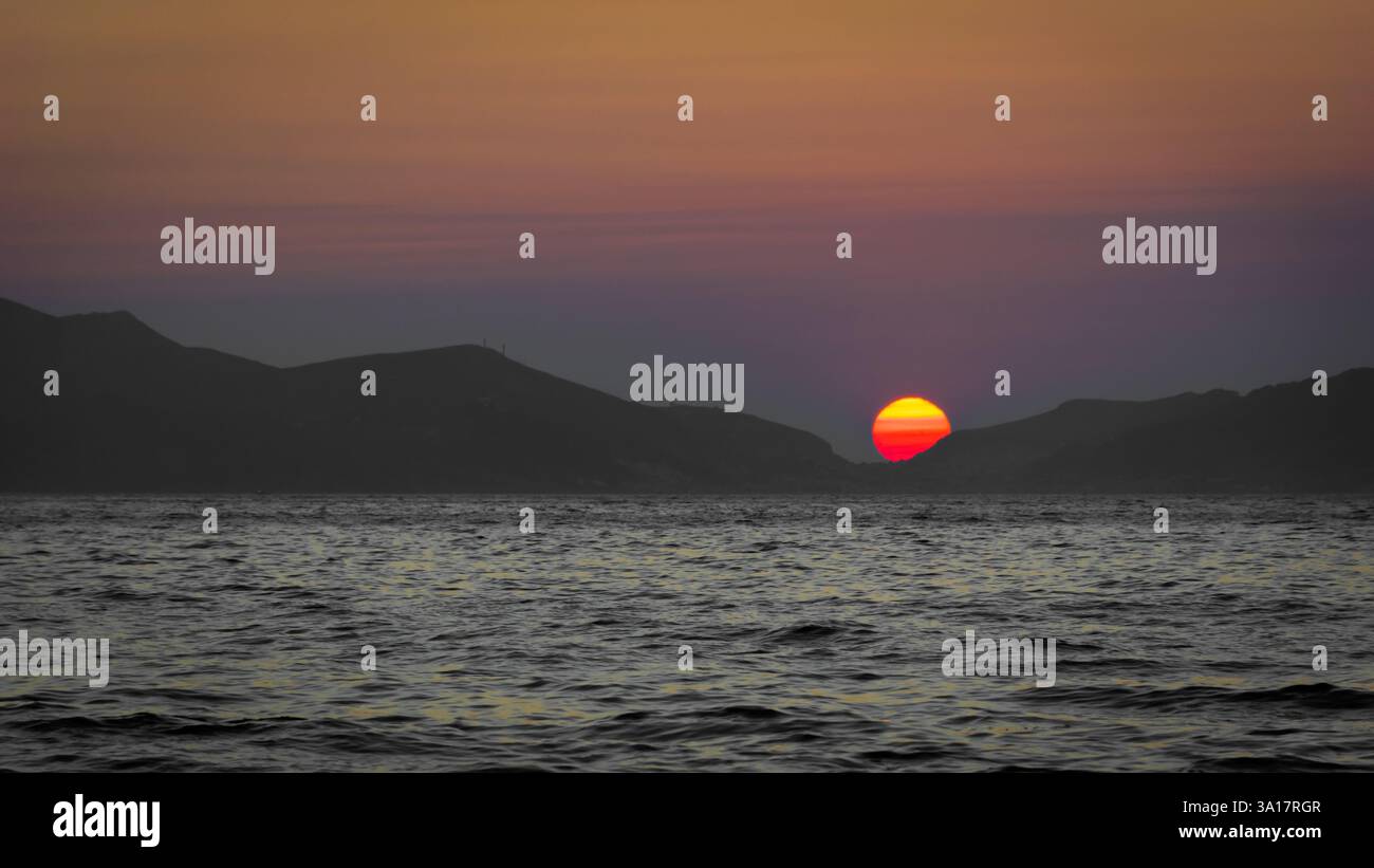 Beach sunset setting behind Kalymnos island from Kos island, Greece ...
